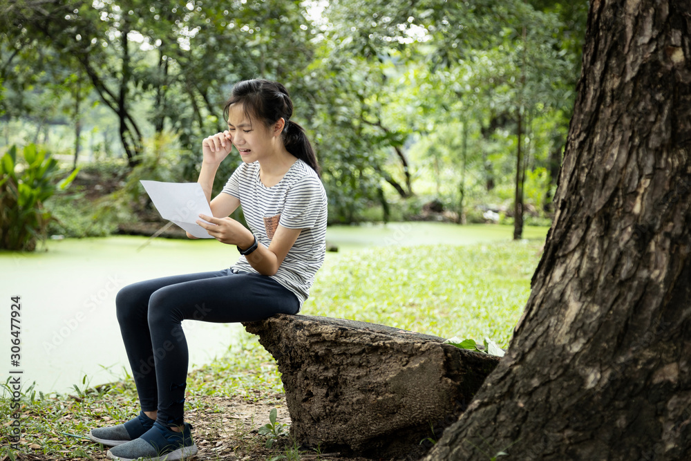 Sad asian child girl sit alone and crying,reading letter,bad news ...