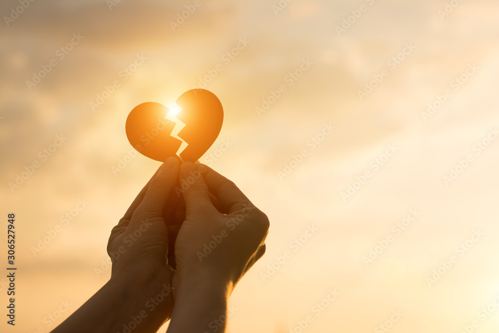 Silhouette broken heart,close up woman hand holding broken heart in the ...