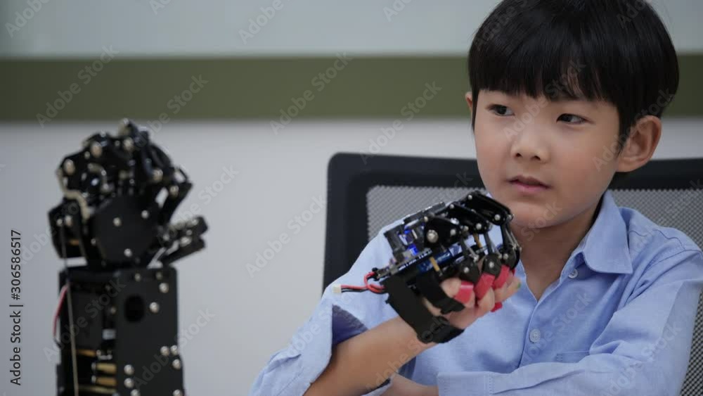 Asian inventor kids assembling and testing robotics responses in ...