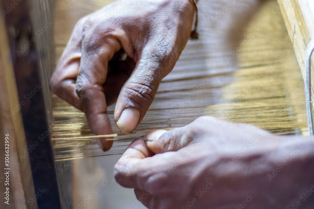 Weaver working with threads on hand powered loom Stock Photo | Adobe Stock