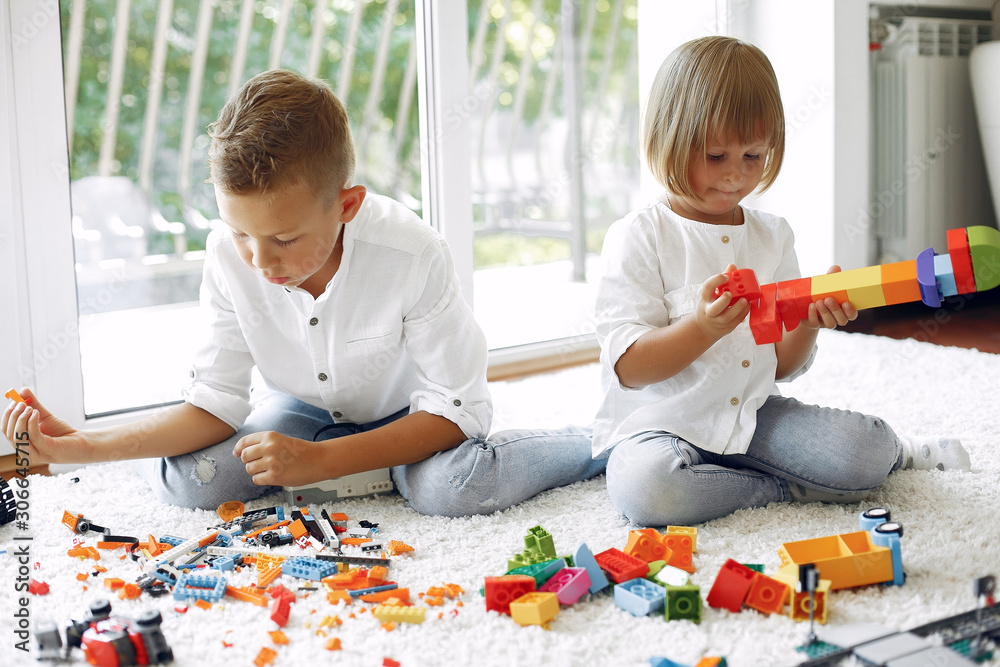 Brother and sister in a playing room. Children playing with a lego ...