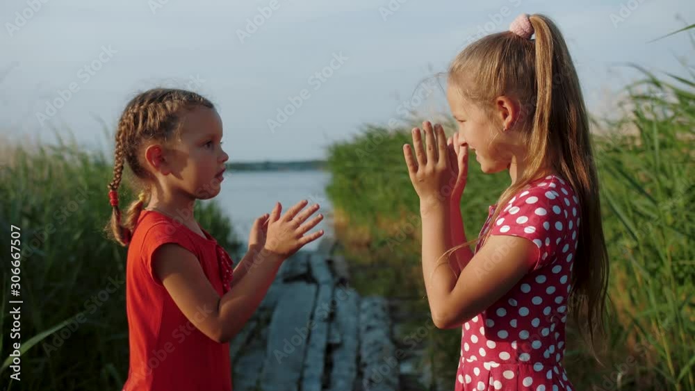 Two little cute girls playing patty cake game, having fun on wooden ...