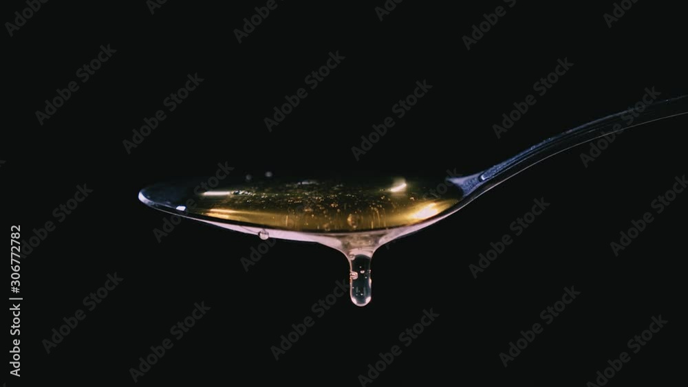 Thick syrup such as honey, maple, corn or cough syrup dripping off ...