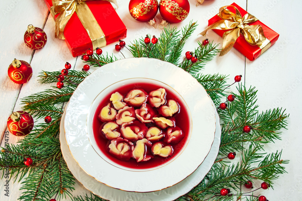 Tradycyjna polska potrawa wigilijna - czerwony barszcz z uszkami, w tle ...