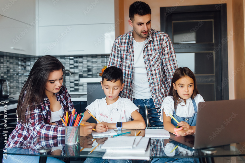 Happy brunette mother with father and their adorable children doing ...