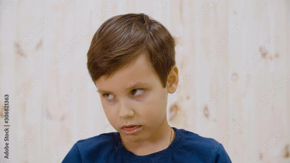 Close up disgusted boy wincing face on light background in studio ...
