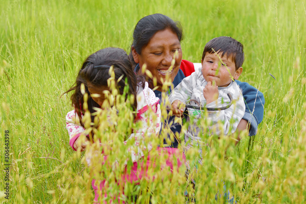 Native american woman with her two kids playing in the grass. Stock ...