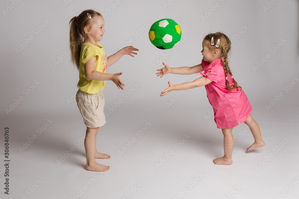 Side view of two cheerful kids throwing and catching ball on isolated ...