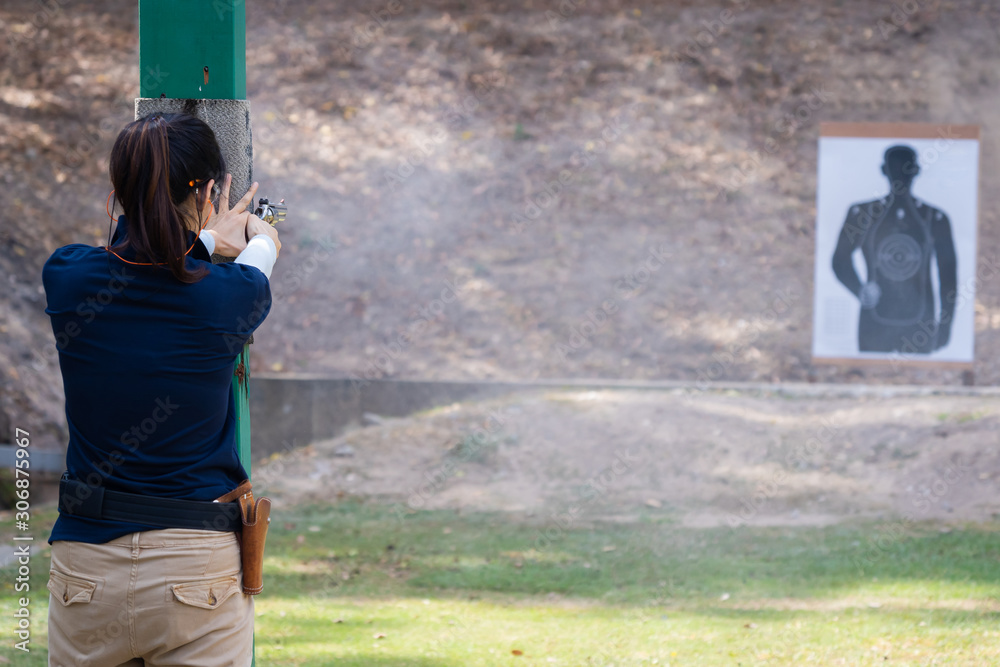Women holding gun aiming pistol in shooting range Stock Photo | Adobe Stock
