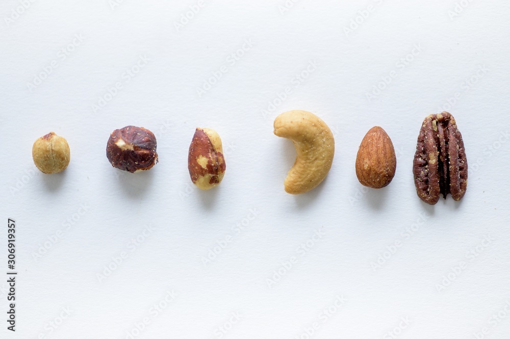 Overhead shot of different nuts in a line on a white surface Stock ...