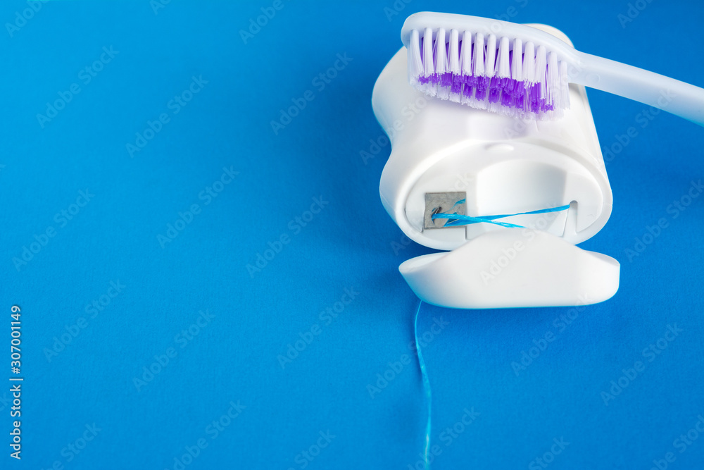 dental floss and toothbrush on a blue background, the concept of care ...