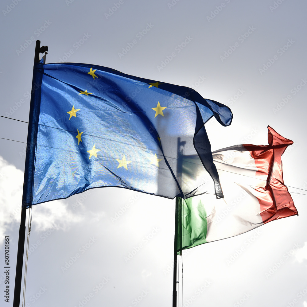 European flag and italian flag waving together in a clear blue sky ...