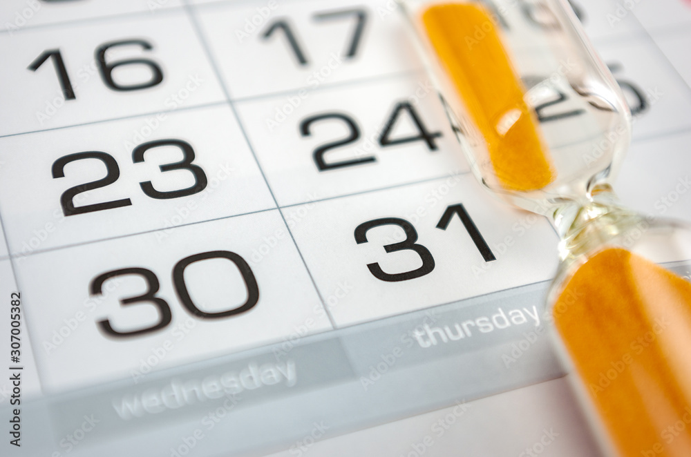 hourglass on the background of the calendar for the month, end of the ...