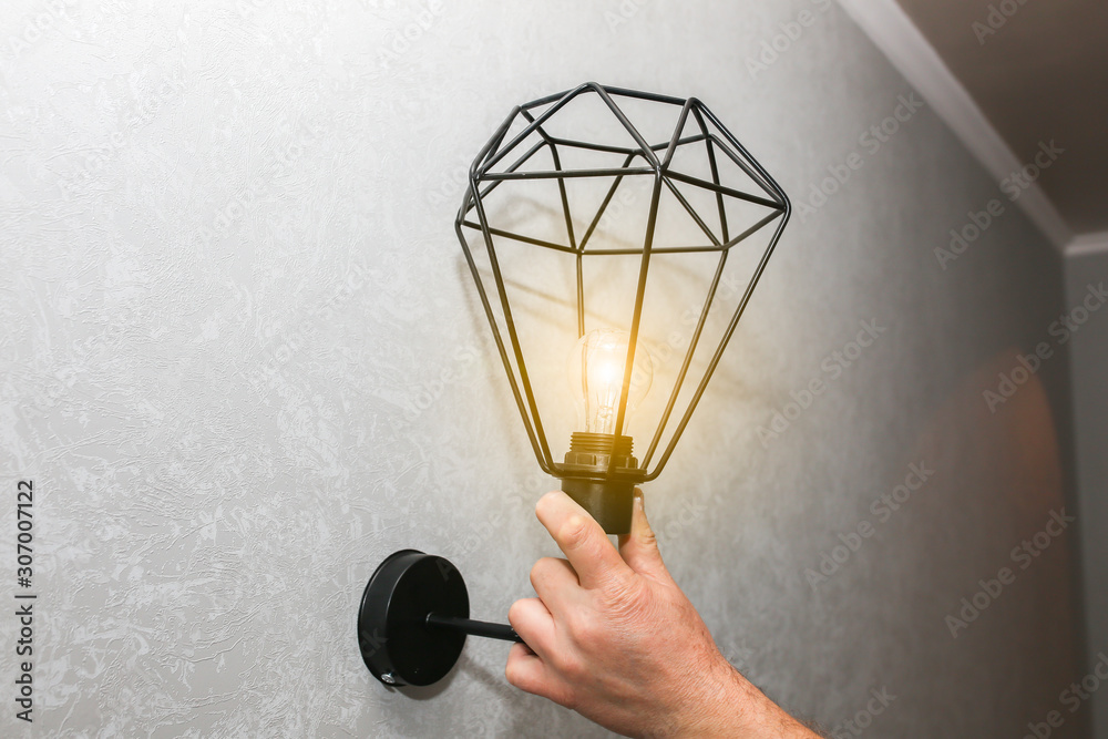 Man holding lamp in hands. Electricity installation. Modern loft design ...