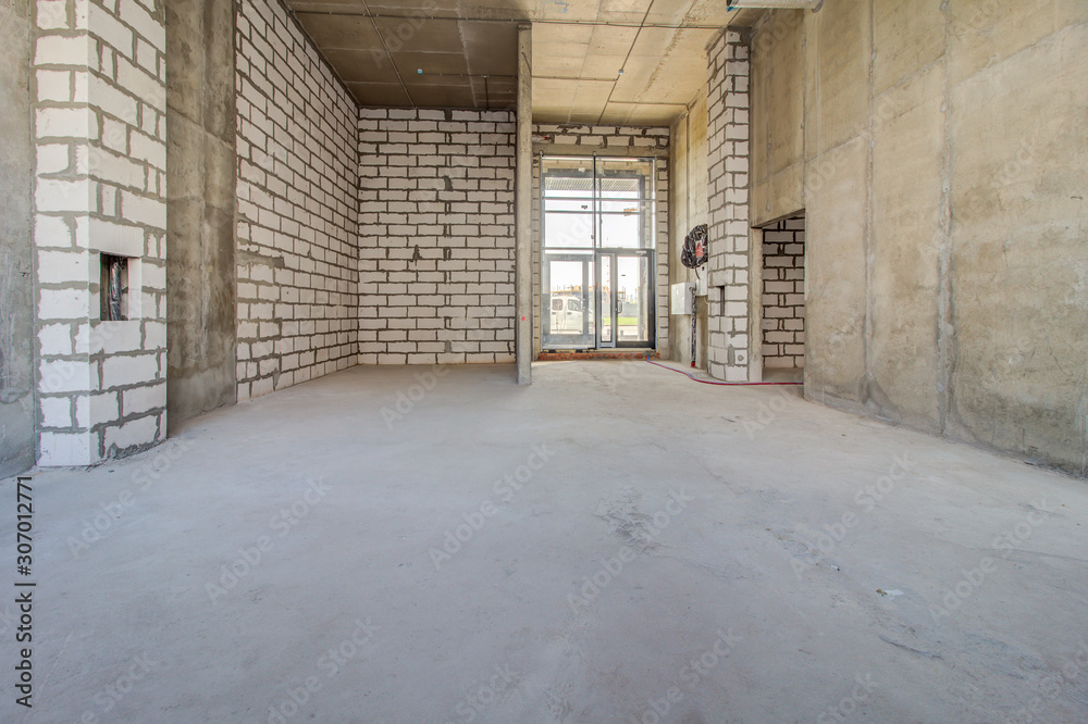 Monolithic brick basement wall. heating pipes lie on floor. New empty ...