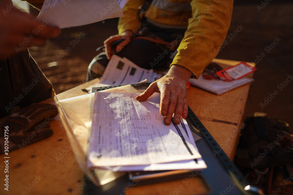 Construction worker double checking paperwork JHA of hot work permit ...