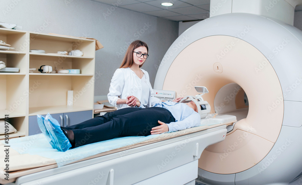 Radiologic model technician smiling help at mature female patient lying ...