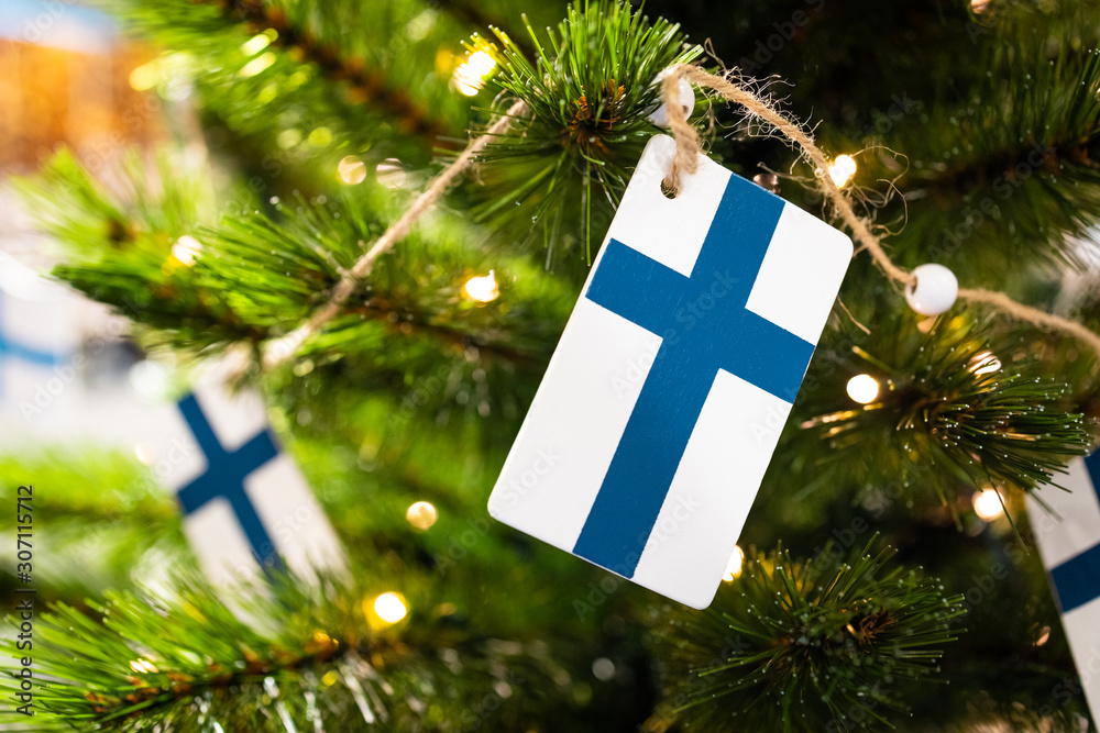 Flags of Finland on a Christmas tree with garland lights in focus ...