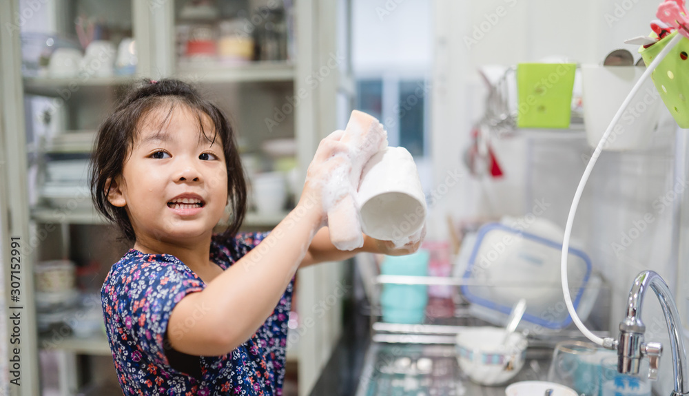 Happy smiley laughing face little cute asian girl washing dishes in ...