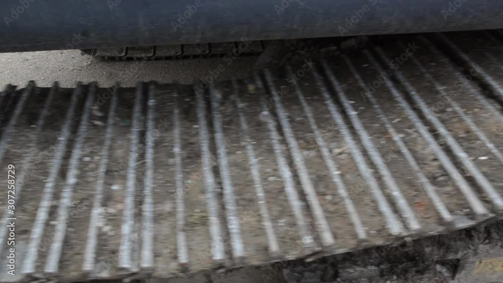 Excavator with dirt on its track pad near construction site, close up ...