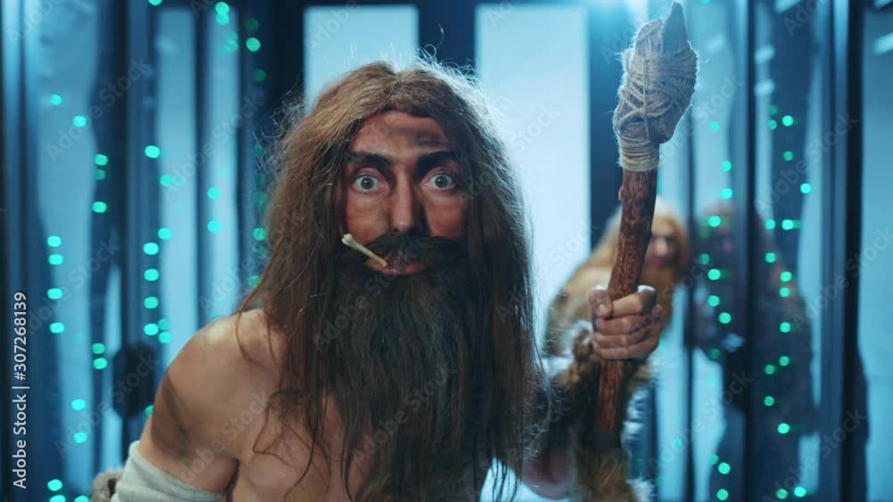 Curious primitive caveman in animal fur exploring futuristic room of ...