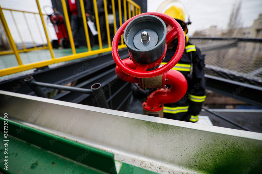 Details with the hands of a firefighter holding a fire suppression ...