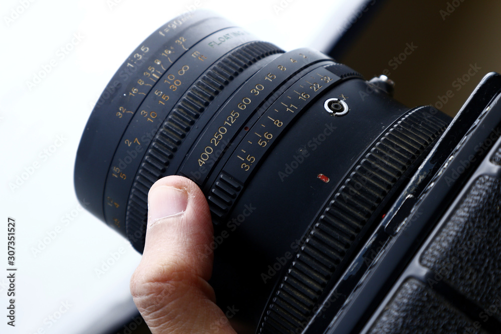 Aperture and shutter speed adjustment ring on the lens of an old and ...