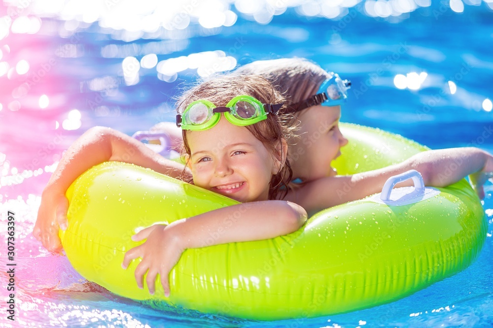 Children playing in pool. Two little girls having fun in the pool ...