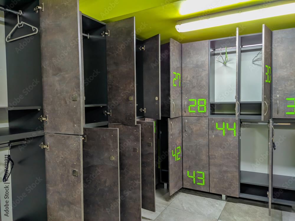 Lockers open in a modern locker room in grey and green colors with ...