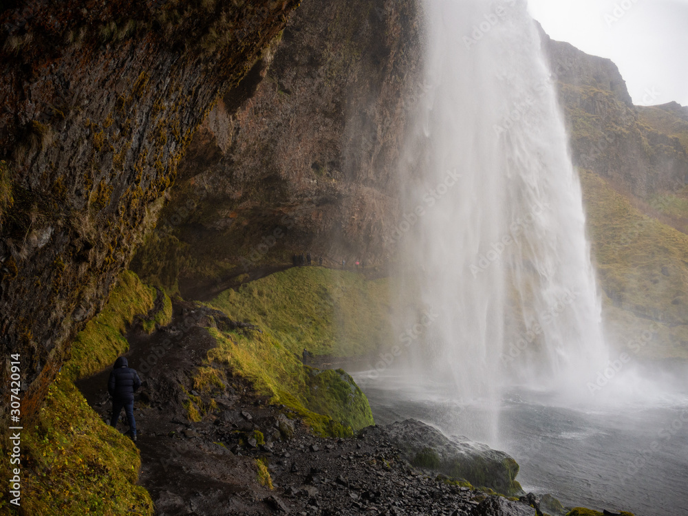 The slippery pathway behind the water curtain of the impressive ...