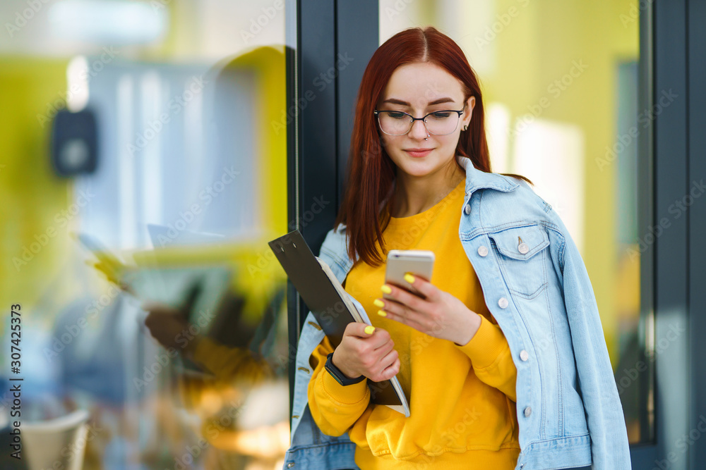 Beautiful woman using telephone in modern office building. Young girl ...