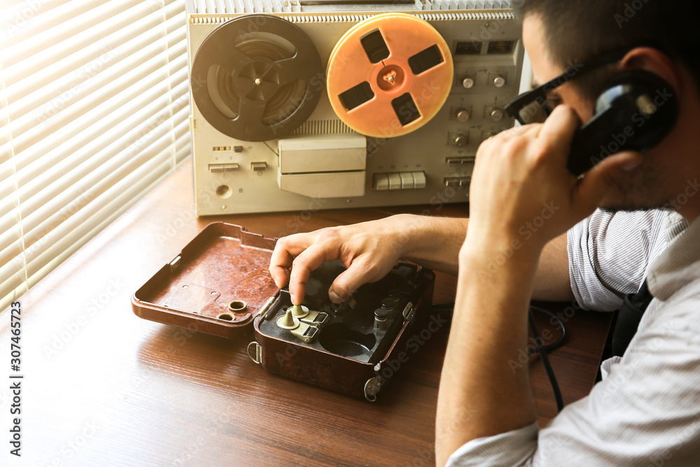 Special agent holds field telephone . Officer wiretapping on the reel ...