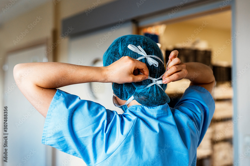 Back view of doctor covering her face with surgical mask Stock Photo ...
