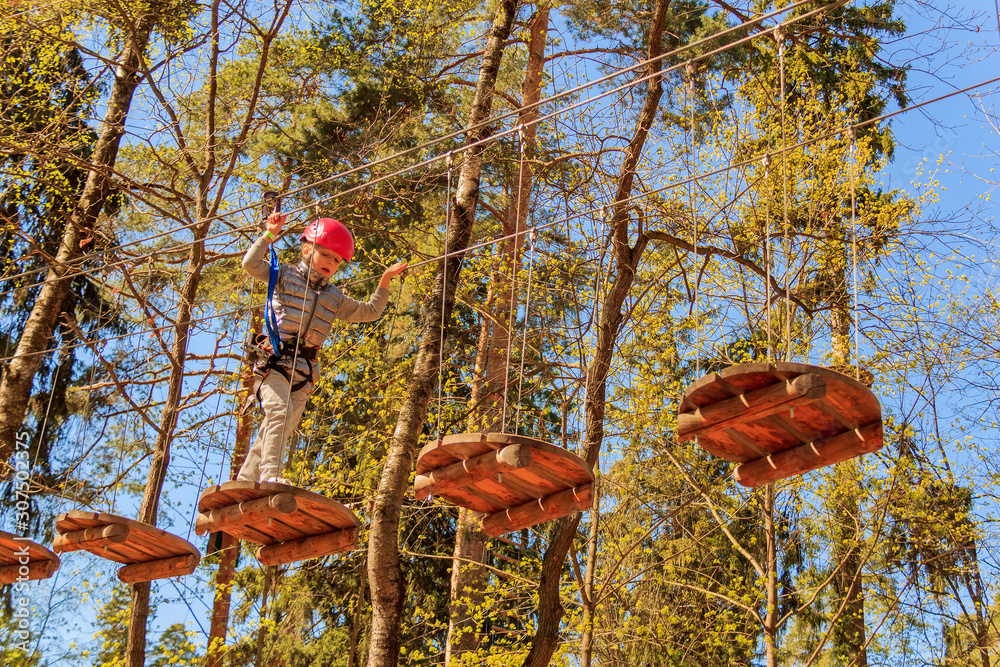 enjoying activity in climbing adventure park. summer day. Rope park ...
