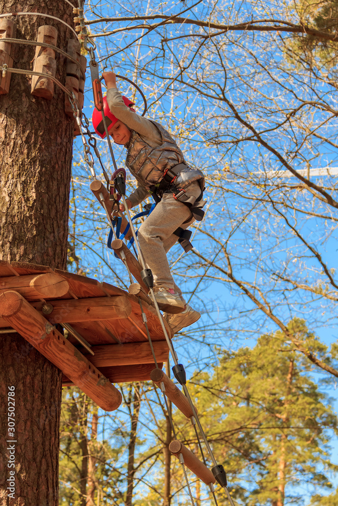 enjoying activity in climbing adventure park. summer day. Rope park ...