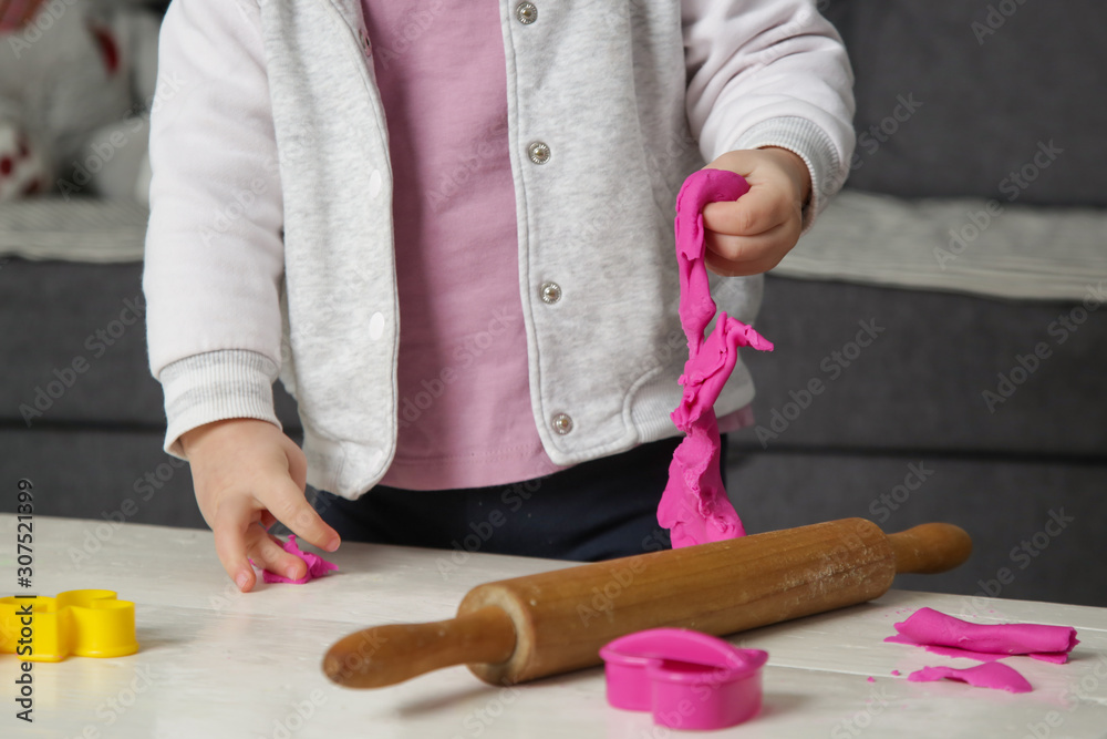 Toddler girl playing with modelling clay. Play dough allows kids to ...