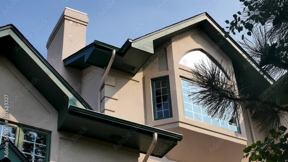 Twisty establishing shot of second story bay windows of a mountain ...