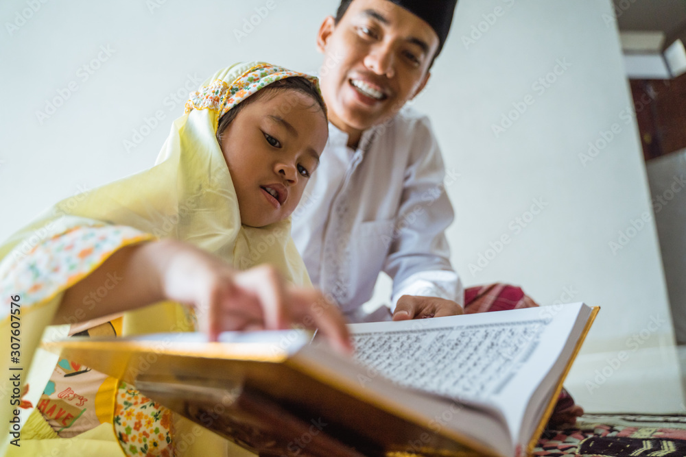 learn how to read qoran. muslim young child with daddy reading holy ...