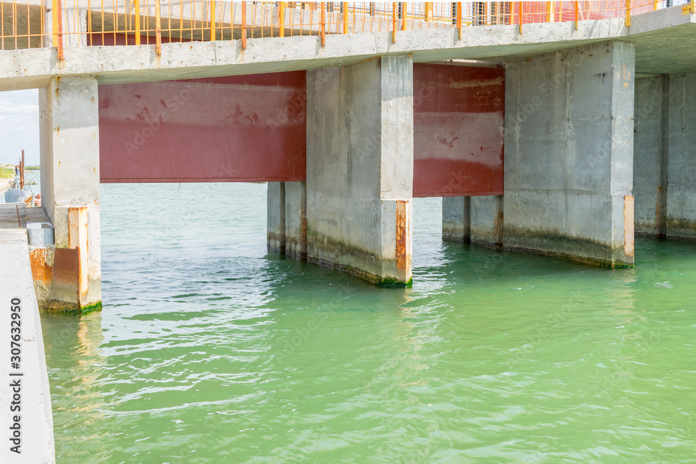Sluice. Gates are open. River estuary on a sea shore. Concrete bridge ...