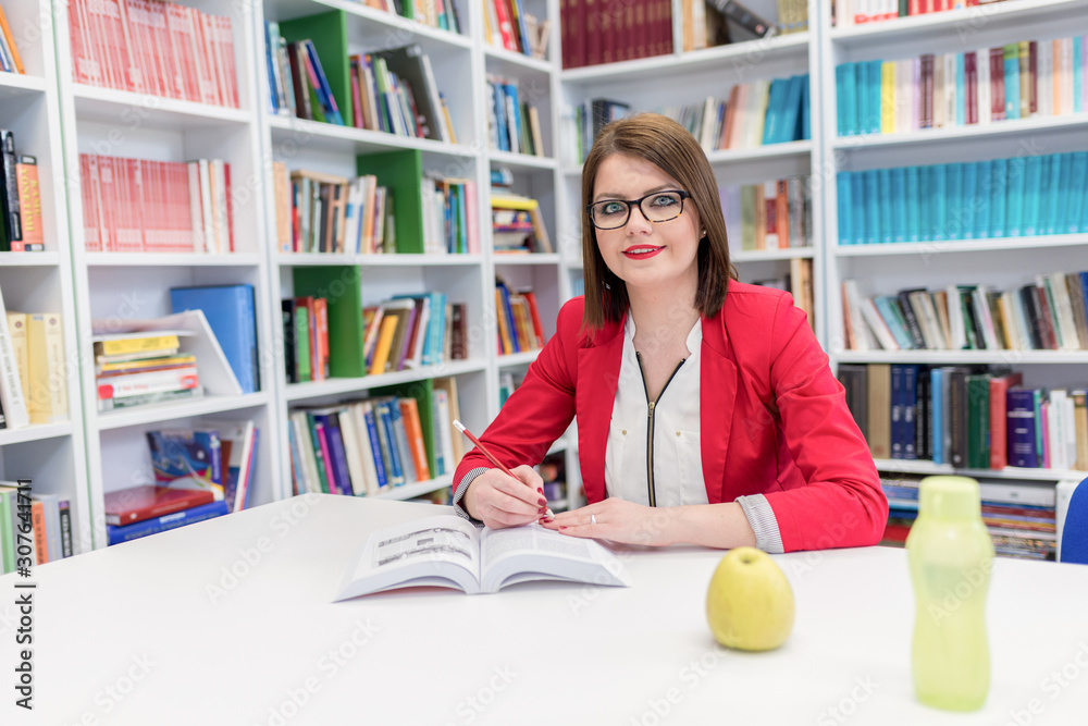Girl in library reading and studying Stock Photo | Adobe Stock