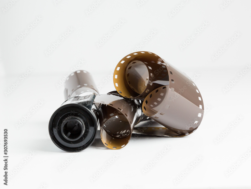 A roll of messy used vintage retro 35mm camera film isolated on a white ...