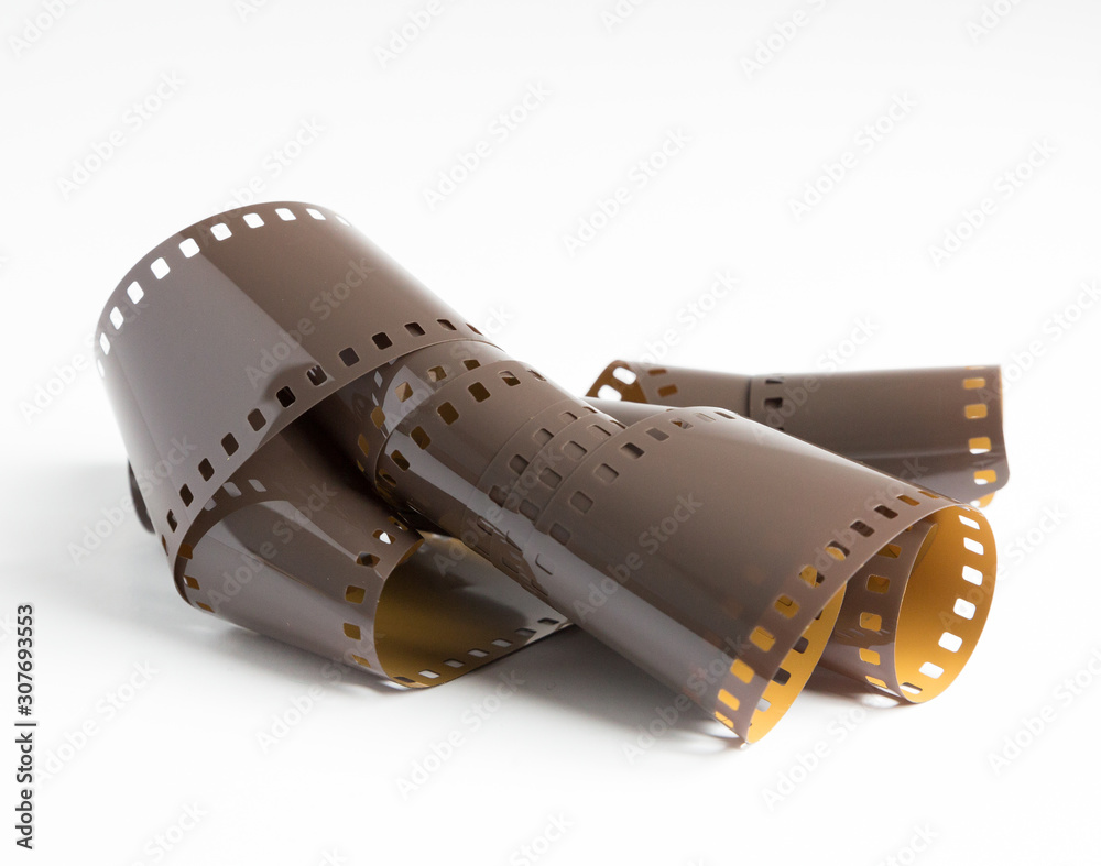 A roll of messy used vintage retro 35mm camera film isolated on a white ...
