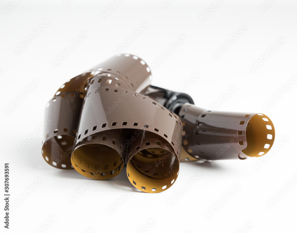 A roll of messy used vintage retro 35mm camera film isolated on a white ...