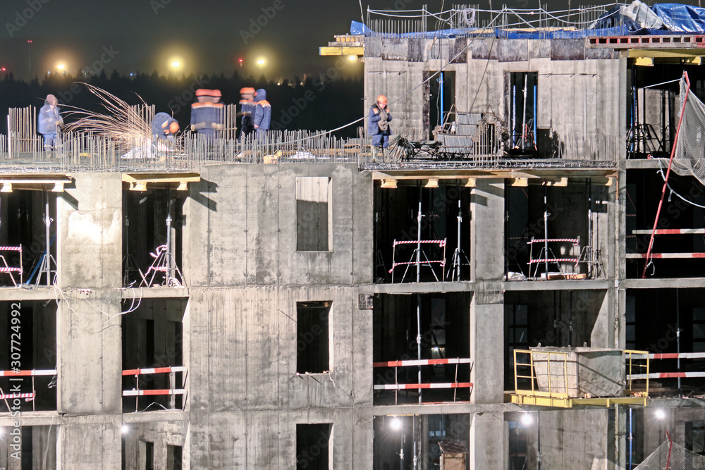 busy people working on construction at site against night dark sky ...