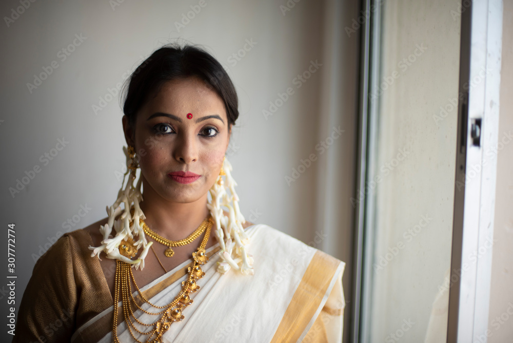 Portrait of an young and attractive Indian woman in white traditional ...