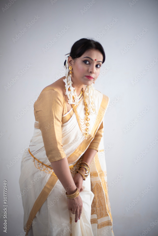 Portrait of an young and attractive Indian woman in white traditional ...