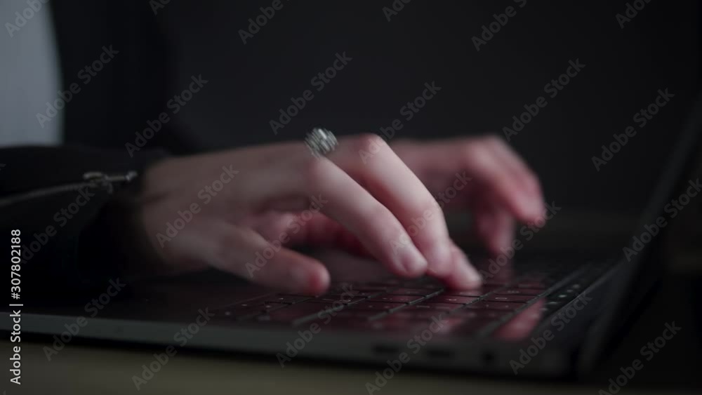 Woman's hands typing fast on a laptop keyboard. Dark environment. Stock ...