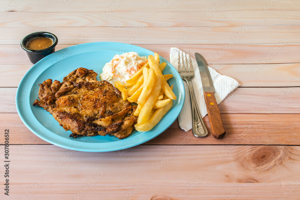 Cajun chicken chop with coleslaw and french fries on blue plate ...