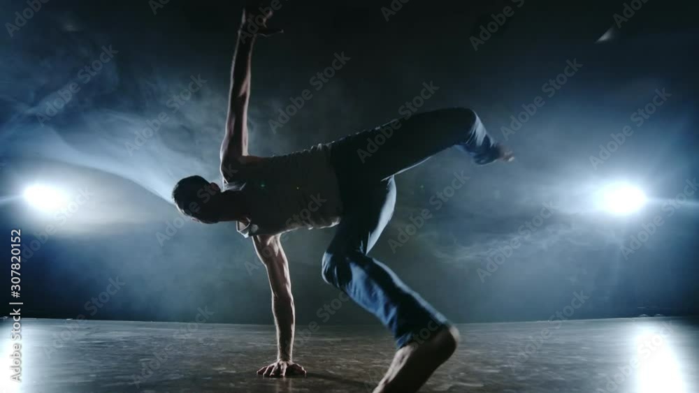 Modern ballet, a man from a sitting position on the stage jumps ...
