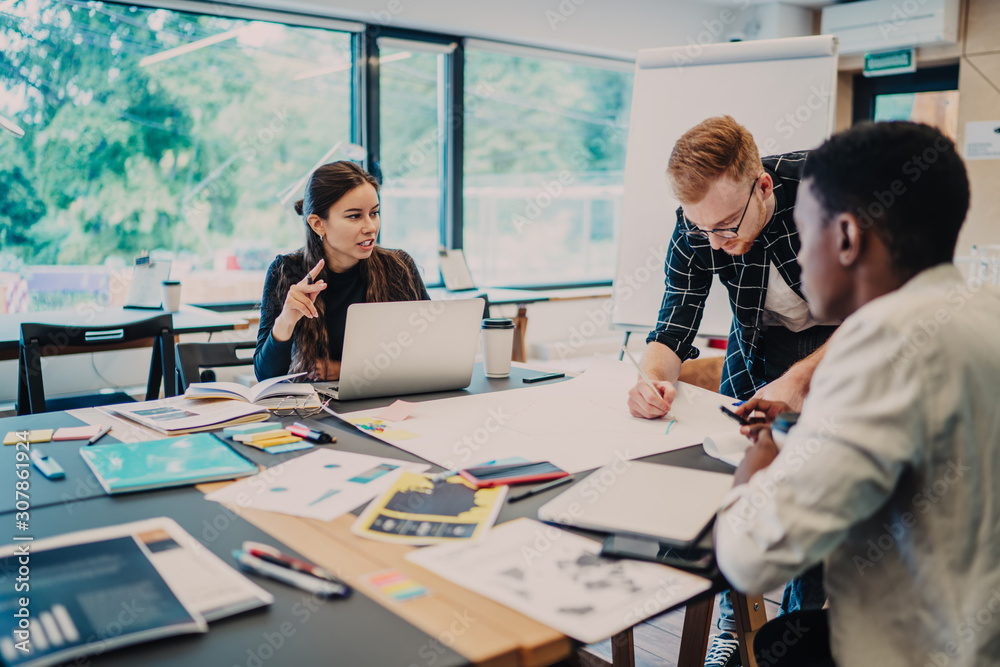 Skilled male and female graphic designers creating new architect ...